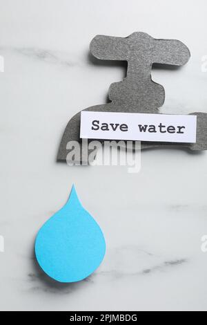 Paper tap with words Save Water and drop on white table, flat lay ...