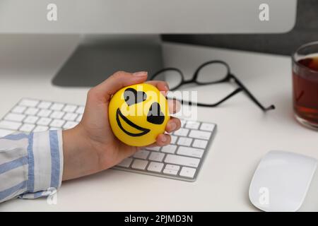 Woman squeezing antistress ball at workplace, closeup Stock Photo - Alamy