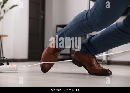 Man tripping over cord in office, closeup Stock Photo - Alamy