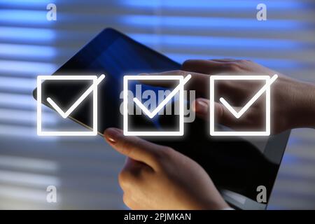 Illustration of check boxes with marks and woman using tablet at wooden ...