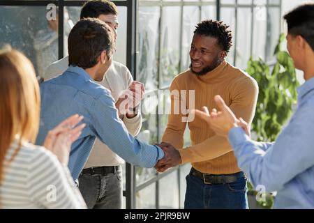 Smiling multiethnic friend getting acquainted in office corridor Stock ...