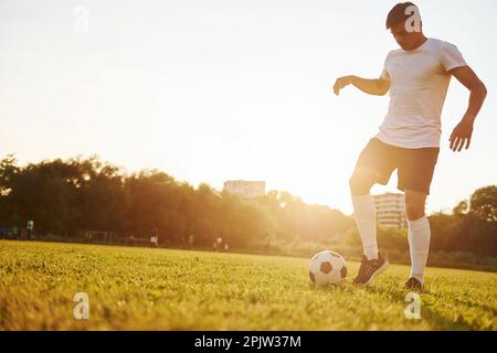 Doing different tricks. Young soccer player have training on the ...