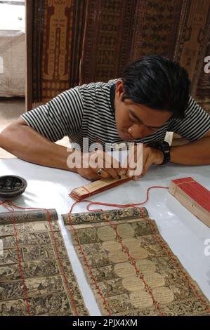 Traditional calligraphy on dried palm leaf at Tenganan village in East ...