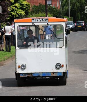 An old fashioned milk float passing through Poulshot village, Wiltshire ...