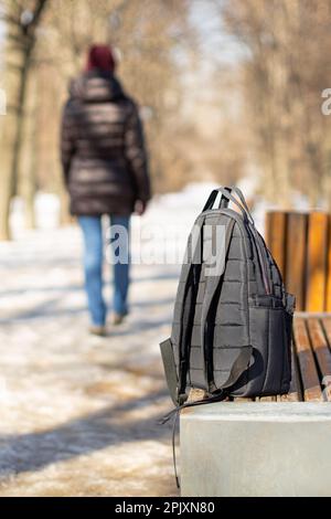 a man forgot his bag on a park bench. women's backpack is on a bench in ...