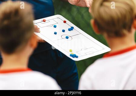 Football coach coaching kids using tactic strategy whiteboard. Soccer ...