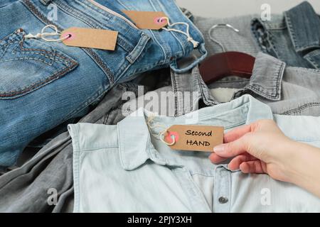 Womans hand holding tag with inscription second hand in store Stock ...