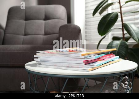Many stacked magazines on table in room Stock Photo - Alamy