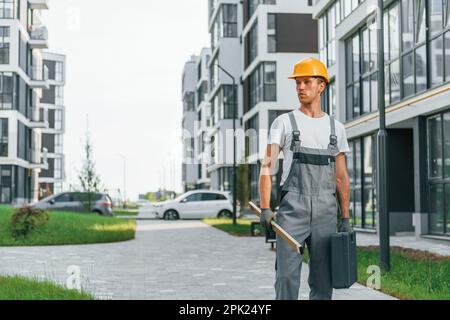 Finished buildings. Young man working in uniform at construction at ...