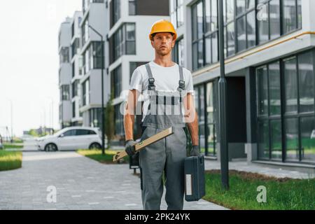 Finished buildings. Young man working in uniform at construction at ...