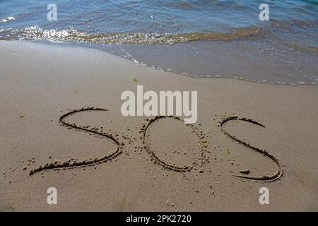 The inscription on the sand at the beach sos Stock Photo - Alamy