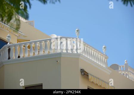 Closeup white concrete balustrade above plastered and painted yellow ...