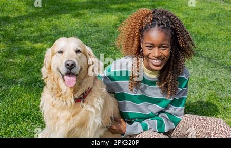 Positive african american girl in fluffy jacket and santa hat looking ...