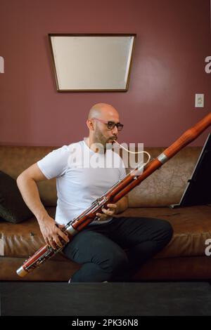 Sitting man with bassoon Stock Photo - Alamy