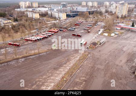 Drone photography of city bus park, lots of parked buses and cityscape ...