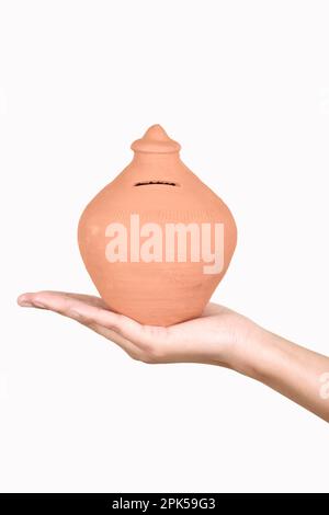 Gullak in hand isolated on white background with clipping path, saving ...