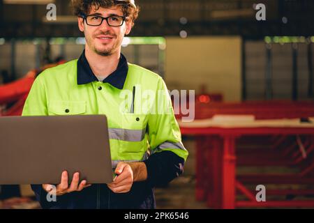 Portrait of happy male mechanical engineer in white hard hat and safety ...