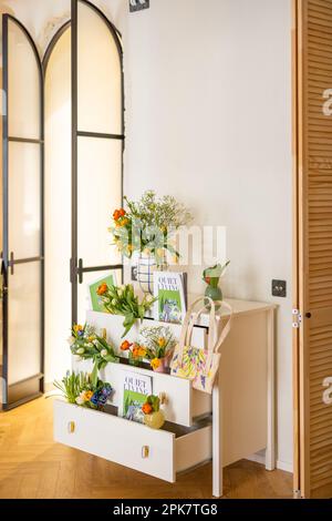 Lots of fresh cutted flowers in white commode indoors Stock Photo - Alamy
