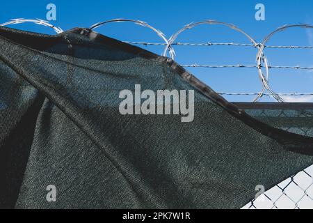 A barbed wire fence and draped fabric Stock Photo - Alamy