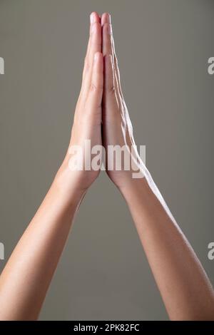 Namaste hand gesture on grey background Stock Photo - Alamy