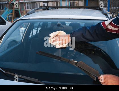 man's hand wipes the dusty windshield of a car with a napkin Stock ...