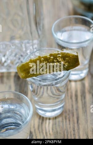 Vodka in a glass and pickled cucumber. Traditional Russian alcoholic ...