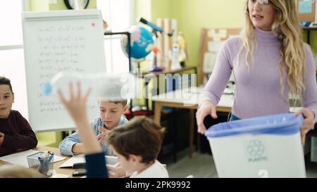Woman and group of kids throwing plastic bottle on paper bin recycling ...