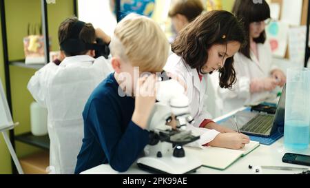 Group of kids scientists students using laptop at laboratory classroom ...