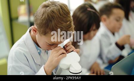 Group of kids students using microscope at laboratory classroom Stock ...
