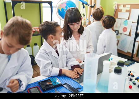 Group of kids scientists students using laptop at laboratory classroom ...