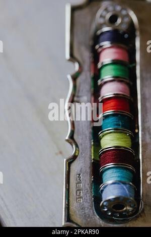 Spools of colorful thread lined in rows are in display at a stall of ...