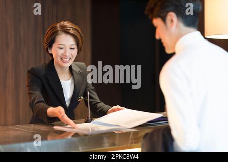 Front desk staff dealing with customers Stock Photo - Alamy