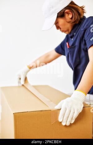 Female worker closing the lid of a cardboard box Stock Photo - Alamy