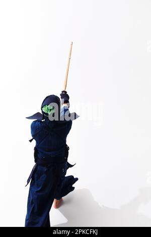 Back view of a man wearing a kendo gown swinging a bamboo sword Stock ...