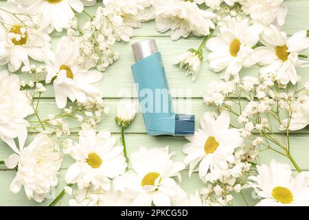 Asthma inhaler with flowers on green background Stock Photo - Alamy