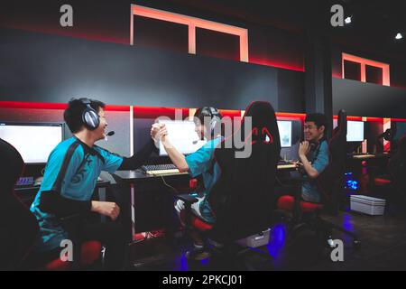 Team of male players posing with guts at an eSports cafe Stock Photo ...