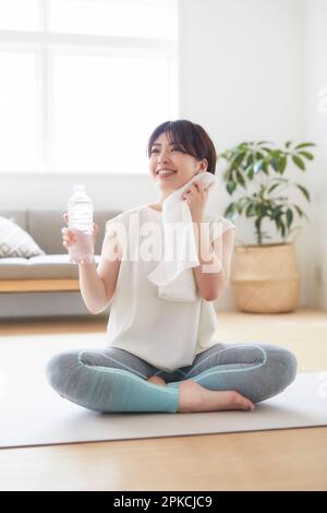 Woman rehydrating with a plastic bottle indoors Stock Photo - Alamy