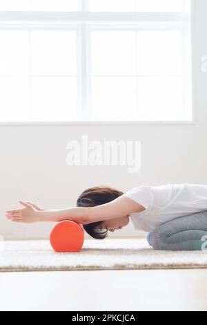 Asian woman stretching arms while using laptop computer on sofa taking ...