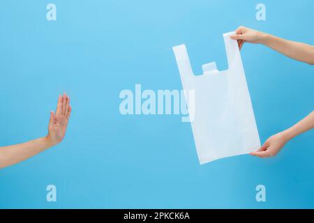 Hand with plastic bag and refusing hand Stock Photo - Alamy