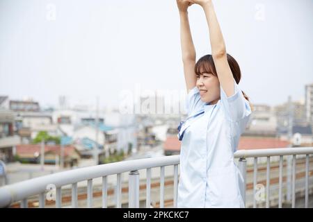 Female Nurse Stretching On Rooftop Stock Photo - Alamy