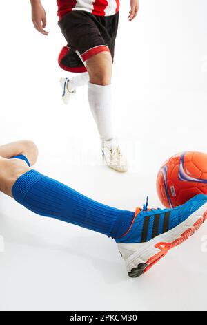 Soccer player sliding to cut off opponent's ball Stock Photo - Alamy