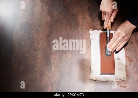 Male hand sharpening a chisel Stock Photo - Alamy