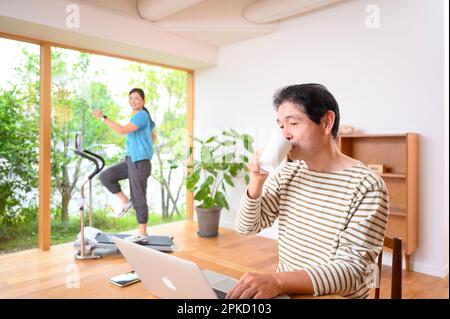 Teleworking middle-aged and older man with running machine Stock Photo ...