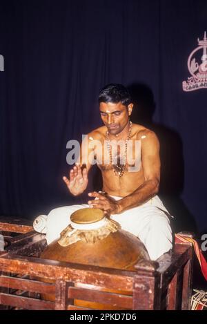 Playing the Mizhavu, a copper drum covered with animal skin during ...
