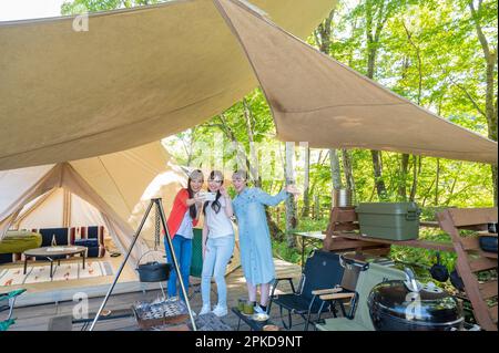 Three women glamping and taking a photo Stock Photo - Alamy