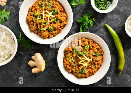 Keema curry and rice in bowls over dark stone background with free ...