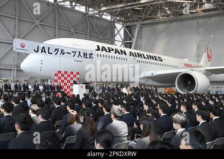 New employees attend the JAL Group entrance ceremony held in a hangar ...