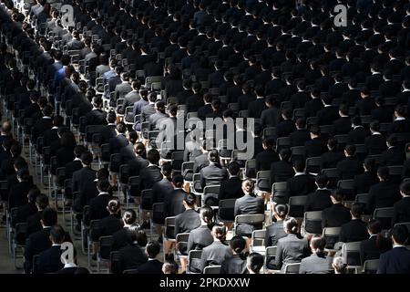 New employees attend the JAL Group entrance ceremony held in a hangar ...
