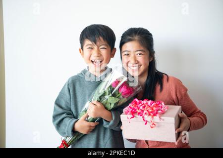 Boy and girl with bouquet of roses and presents Stock Photo - Alamy