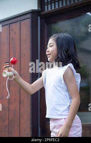 Girl playing kendama Stock Photo - Alamy